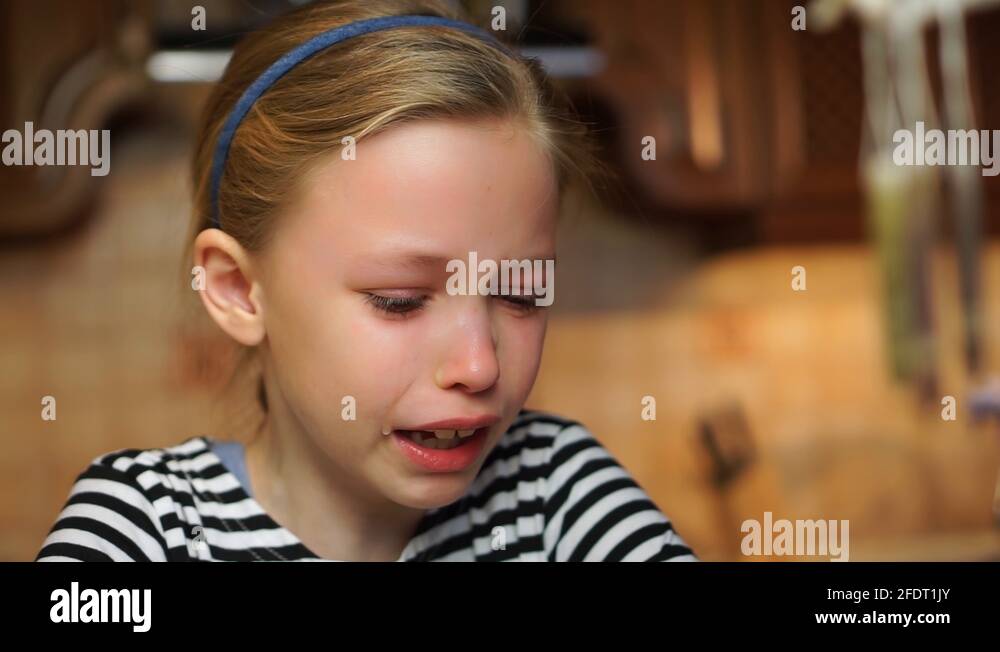 Blond beautiful child girl in striped dress crying badly tears drop ...