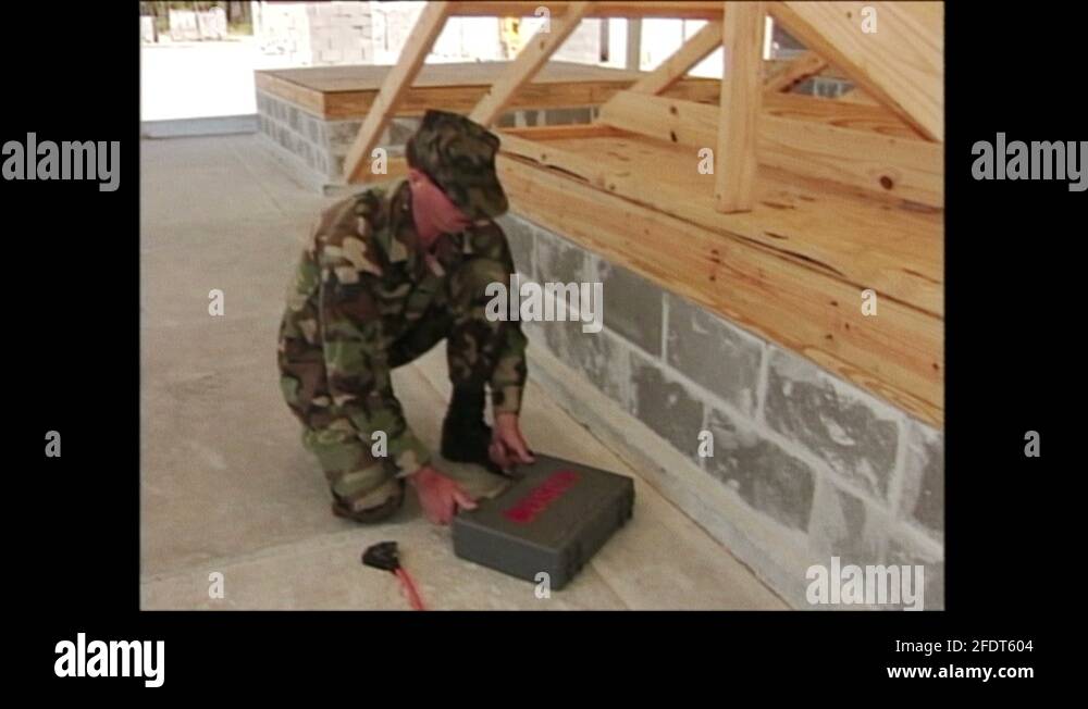 2000s: Man in army fatigues kneeling on ground opens toolbox, pulls out ...