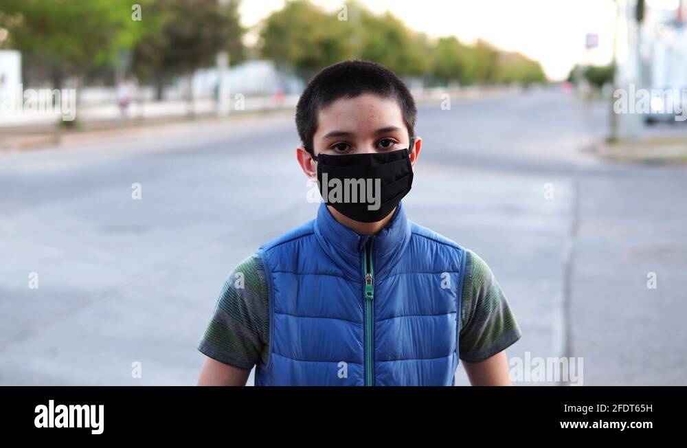 boy covering his face with black mask, mouth cover in the face of the ...