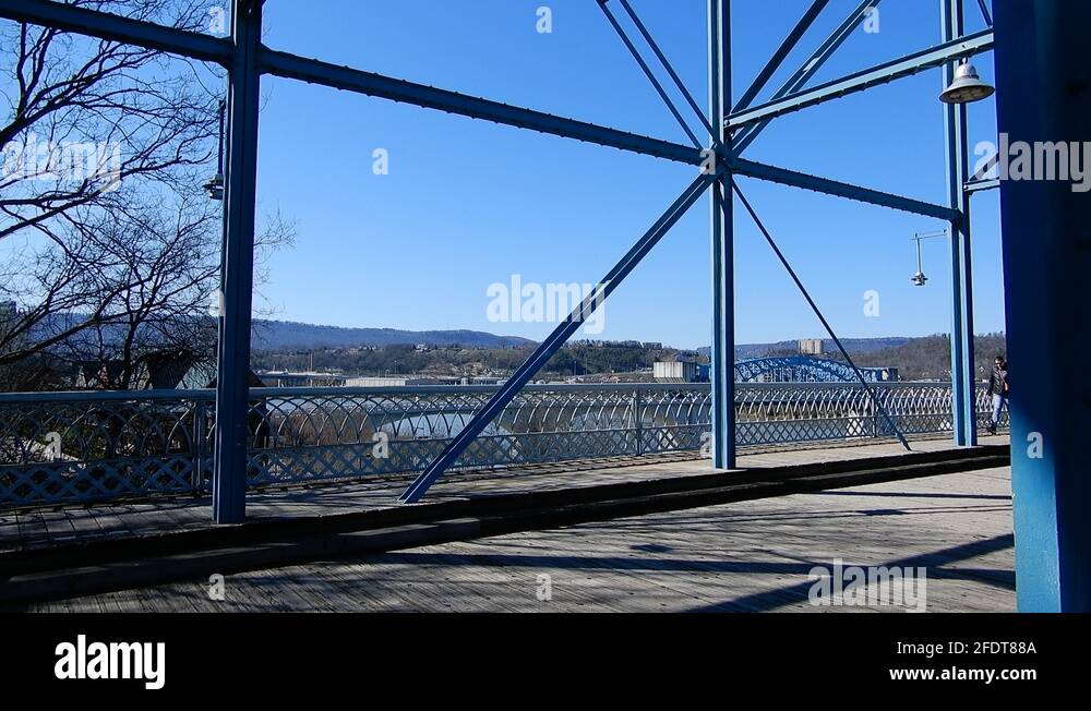 Two People Walking Down Footbridge With Traffic Cars Driving Down ...