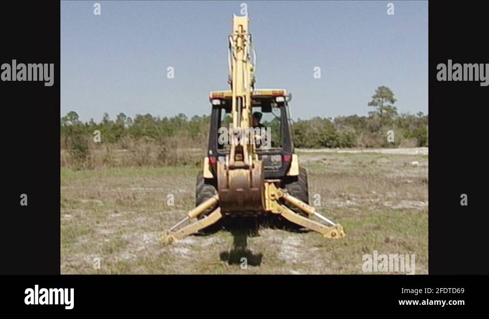 2000s: Front view of excavator digging, bucket lifting. Excavator ...