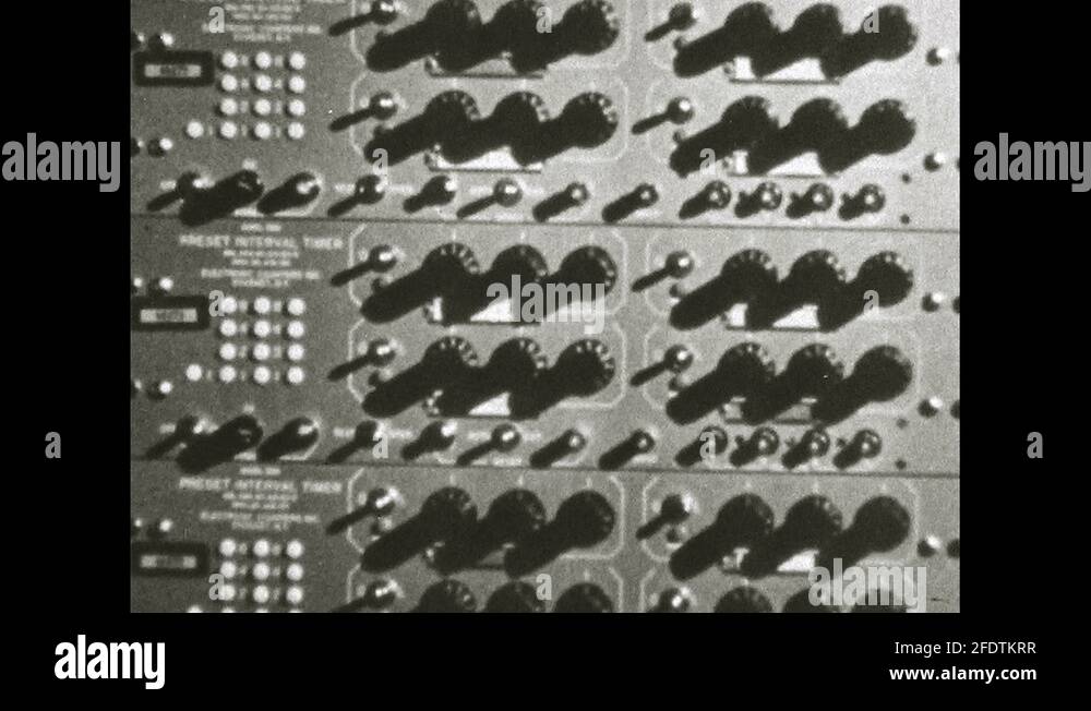 1960s: control panel with dials and switches, man turns dial on ...