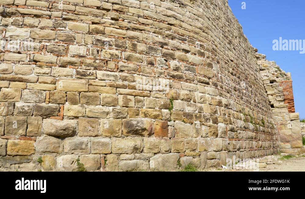 Ruins of castle tower with stone walls and arched bricks facade of ...
