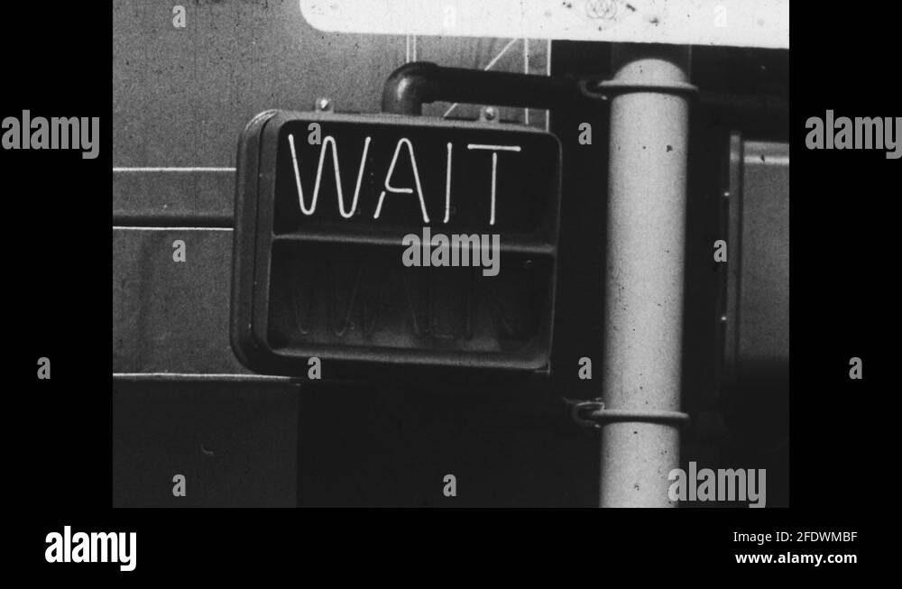 1960s: walk and wait signals direct pedestrians to cross street, cars ...