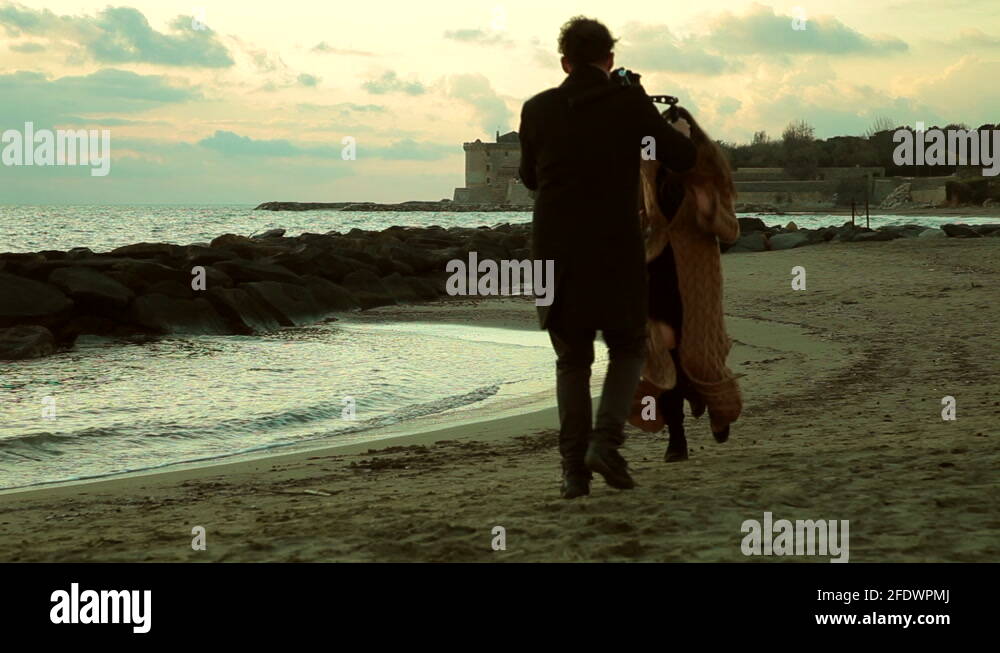 Scene of action movie woman running quick in front of ocean at sunset ...
