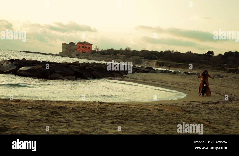 Scene of action movie woman running quick in front of ocean at sunset ...