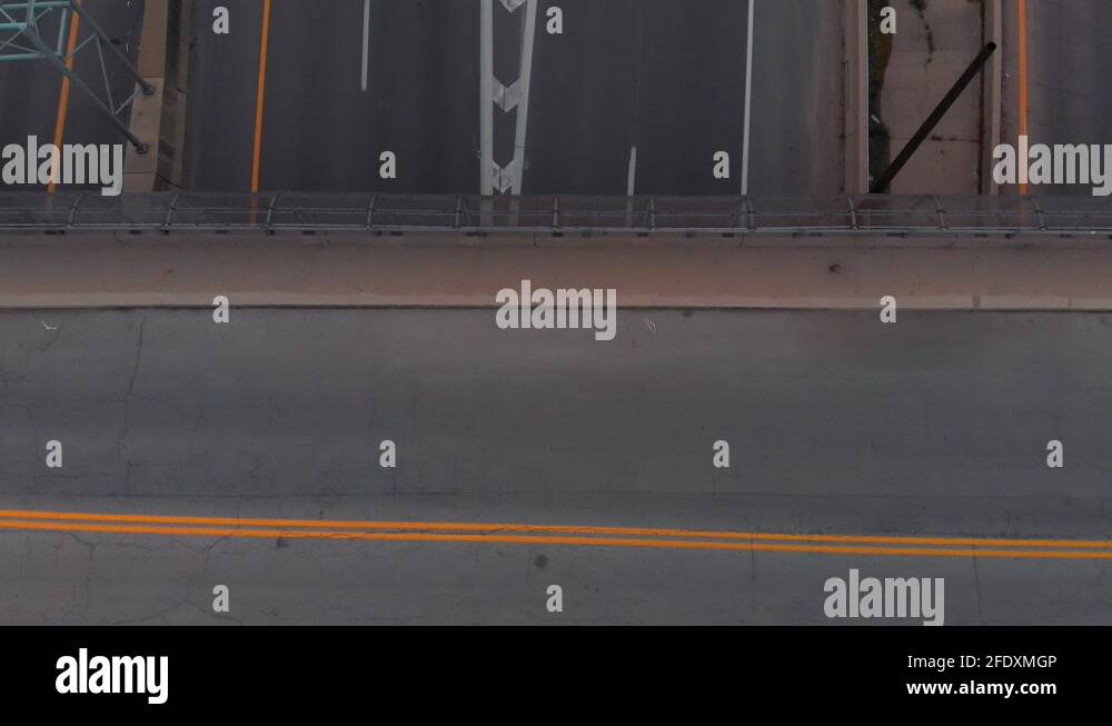 Four-lane highway of vehicular traffic under two-lane bridge, directly ...