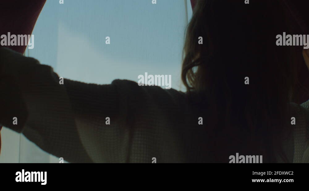 Lovely girl is awake and standing before window. Beautiful woman ...