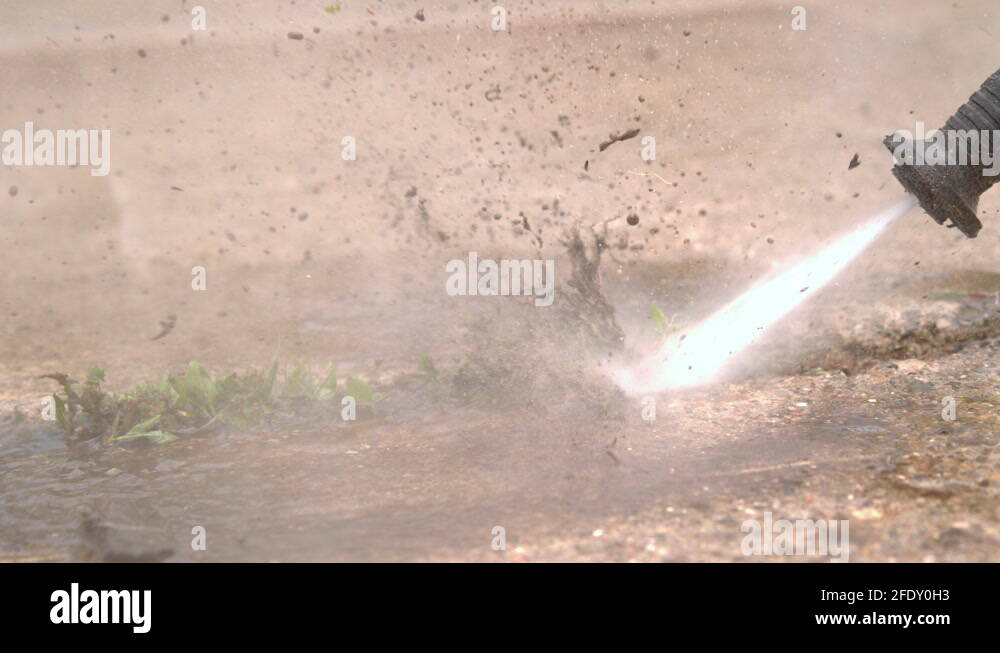 Mud exploding out of concrete cracks from pressure washer slow motion ...