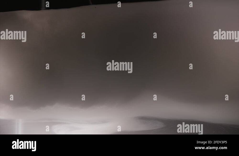 Cloud tank with rolling fog and ink shot against black, on and in water ...