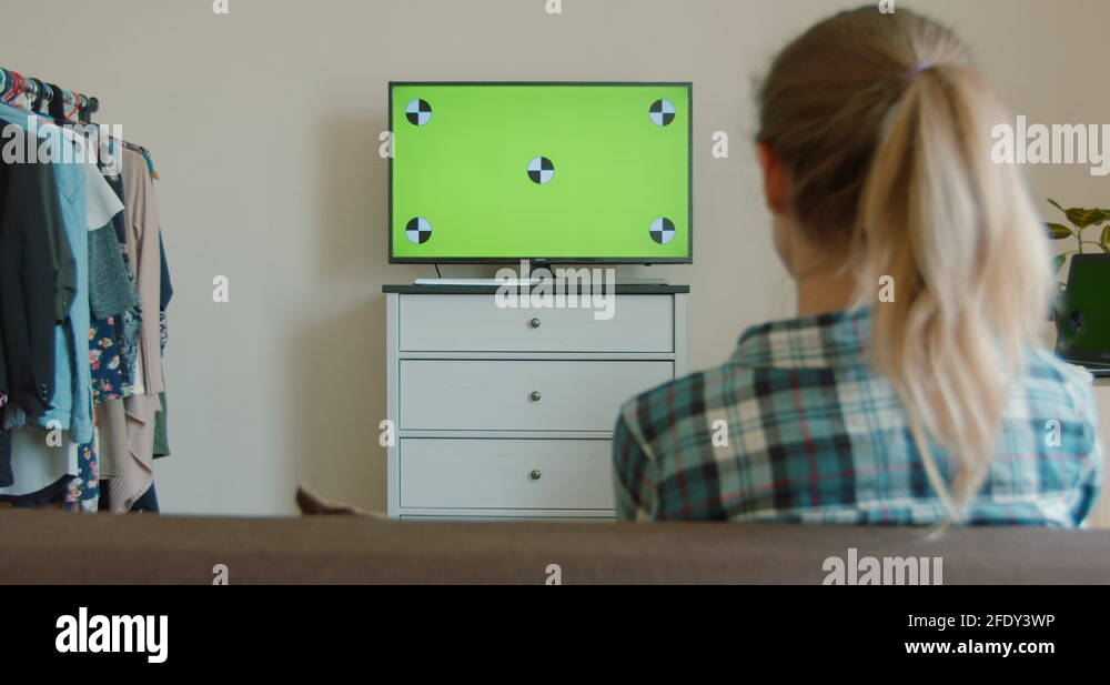Television green screen, pretty girl watching modern TV at home and ...