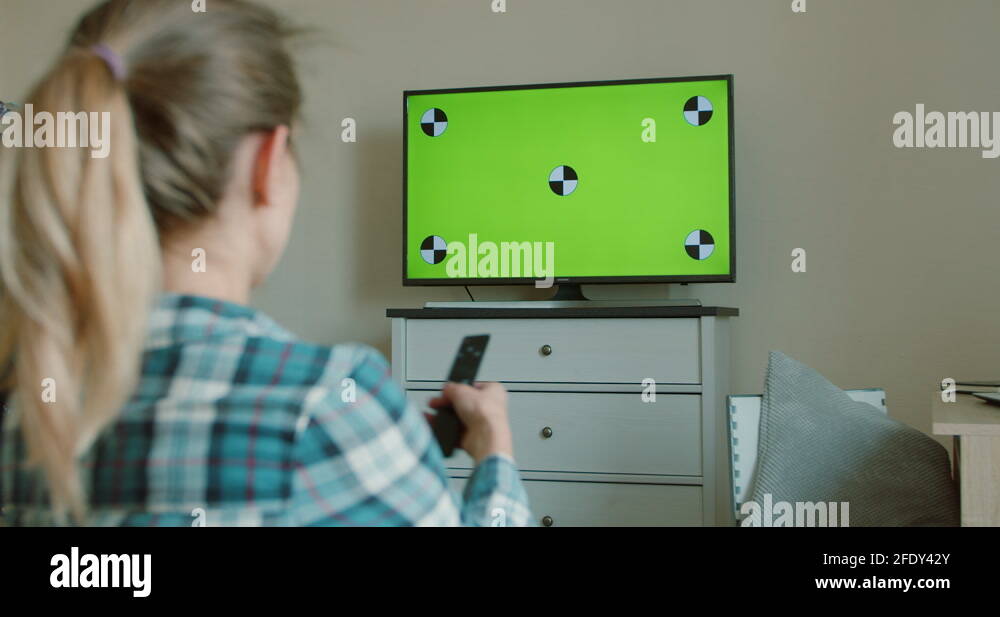 Television green screen, pretty girl watching modern TV at home and ...