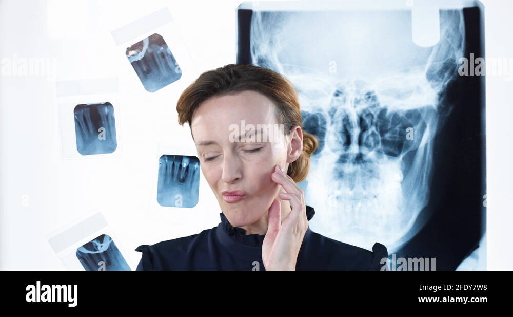 Caucasian woman touching her cheek and suffering of toothache with x ...