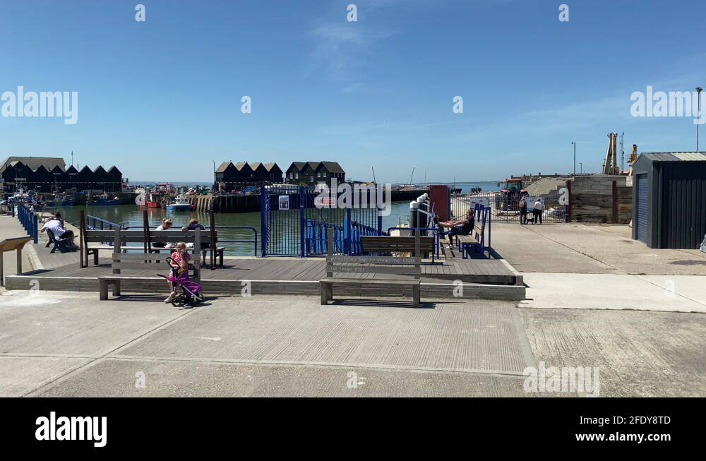 Panning shot of whitstable Beach harbour in summer on hot day with ...