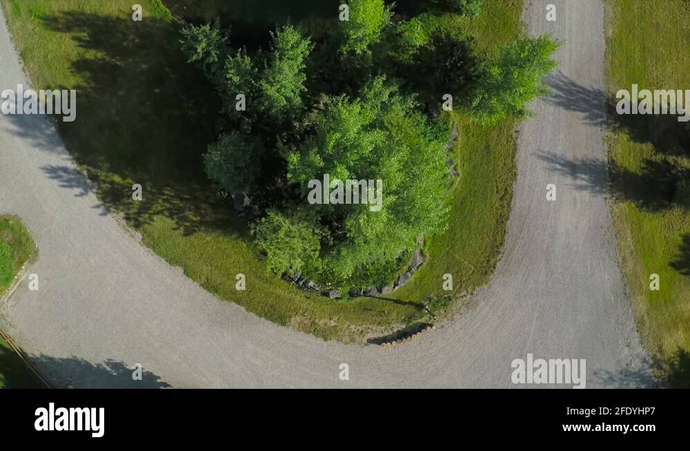 Overhead top down view of hourglass fish pond tilt up to reveal meadow ...