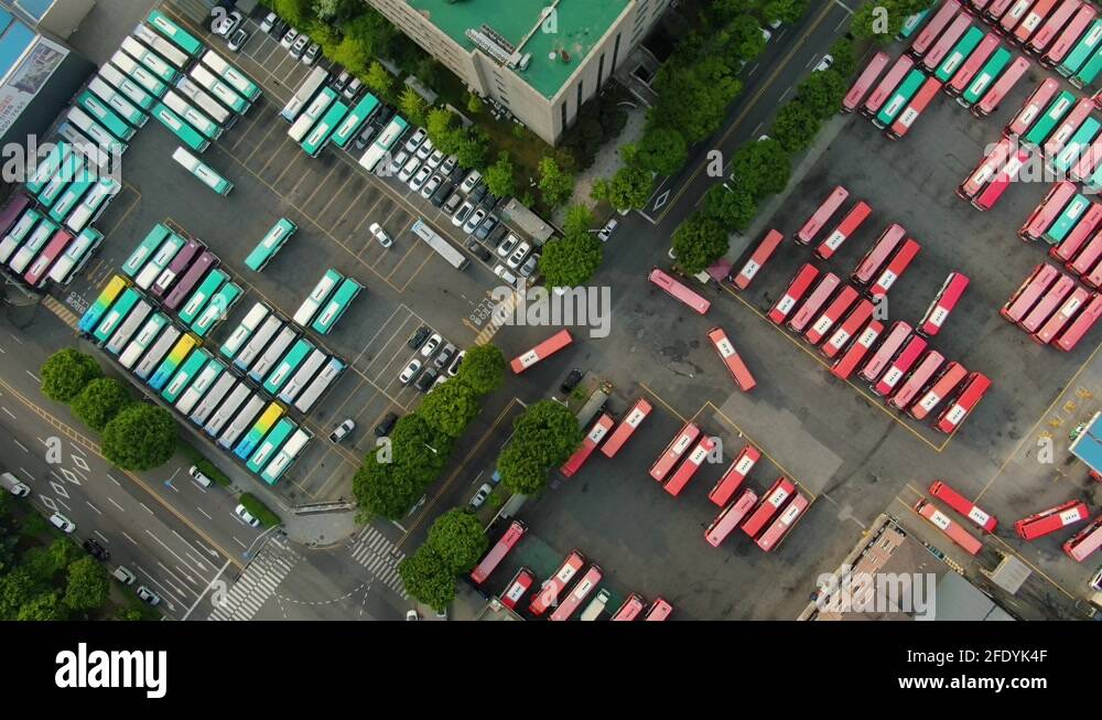 two bus garages with various colors of buses running in the form of an ...