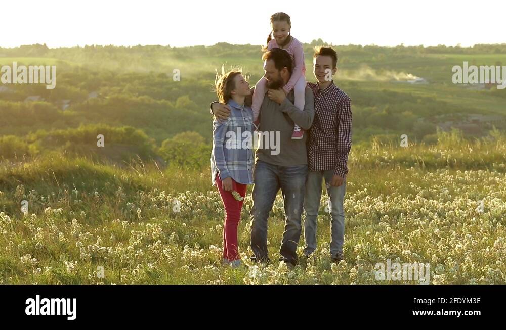 a father with three children in nature, a man hugs his daughters and ...