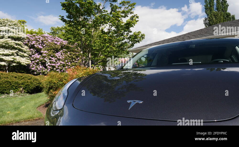 A gray Tesla Model 3 in the driveway of an upscale home, Seattle ...