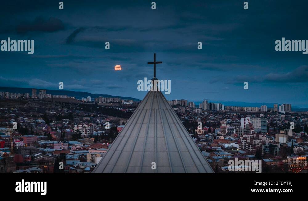 Moonrise behind Christian cross on top of a church. Night time-lapse ...