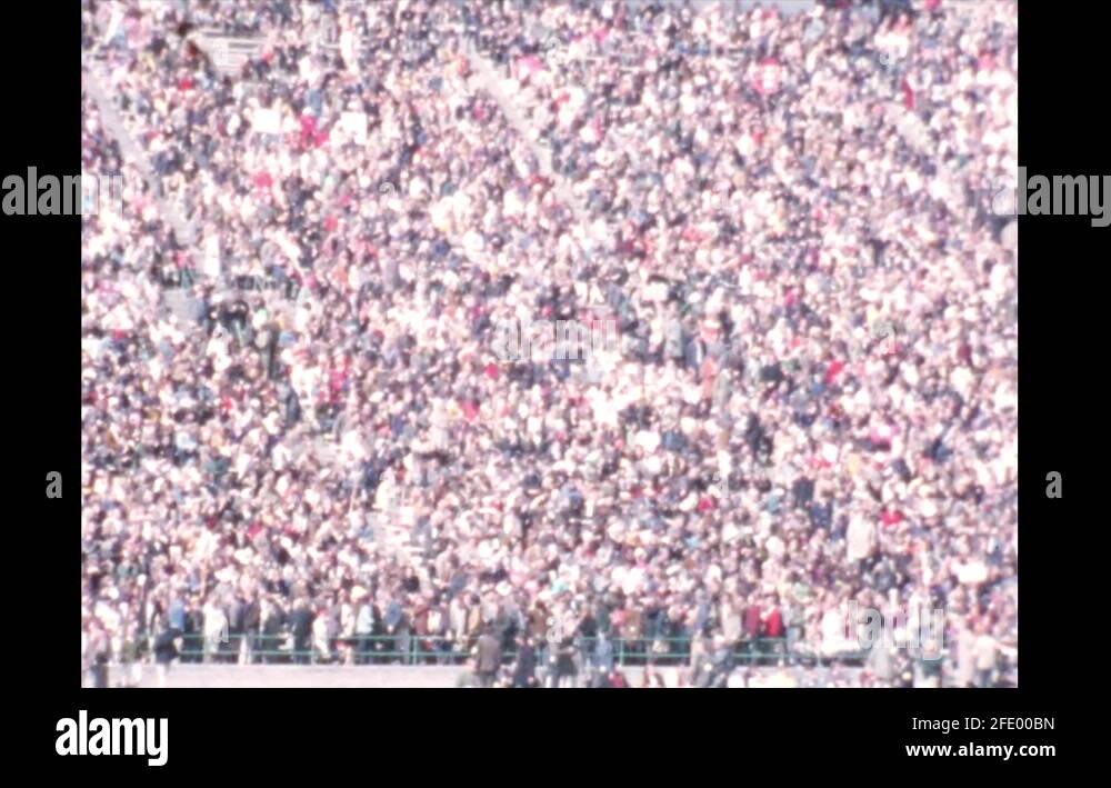 1960s: Huge crowd of people in stadium seats. People gather around ...