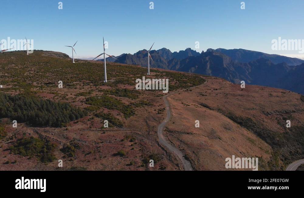 Wide panoramic shot over highland field wind turbine energy farm ...
