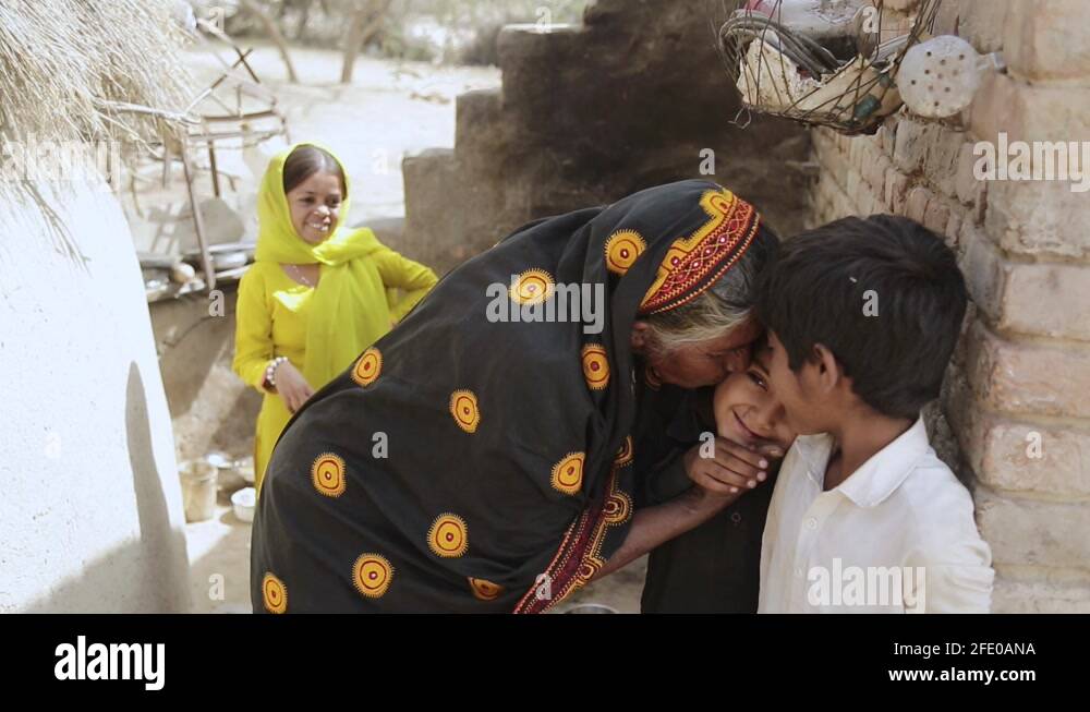 Old dark skinned woman, living in poor conditions, smiling and kissing ...