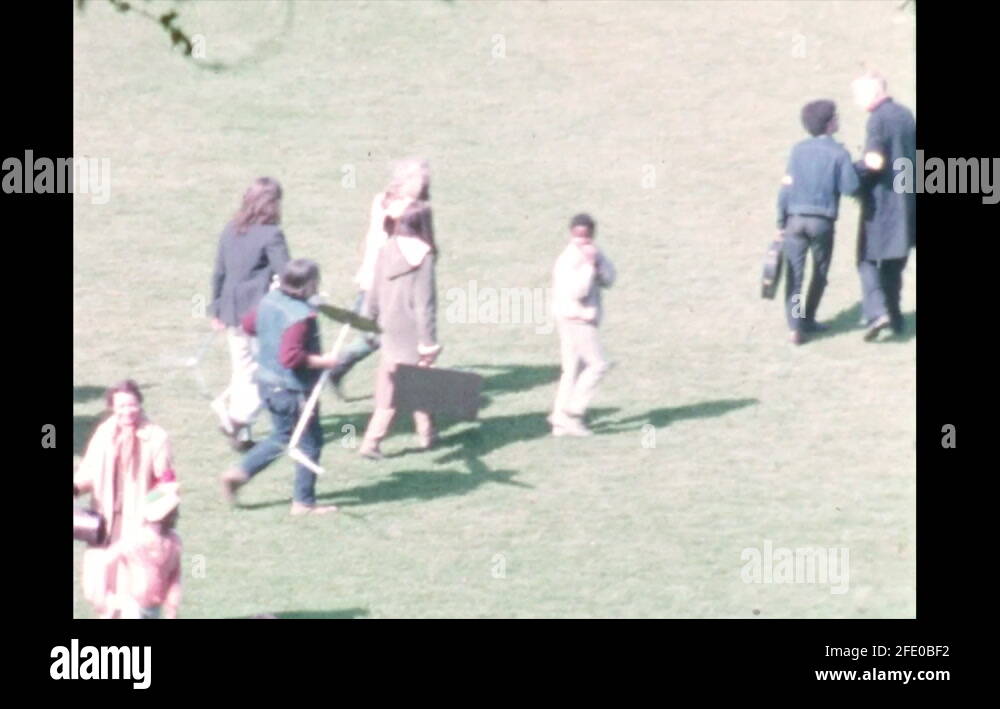 1960s: Musicians carry instruments and amps across field in stadium ...