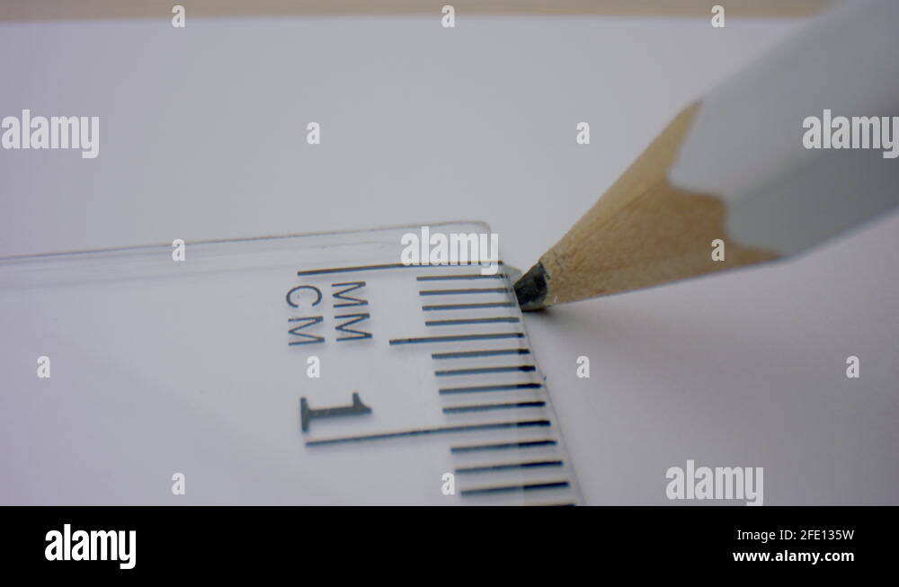Pencil drawing straight line on paper. Architect using ruler for sketch ...