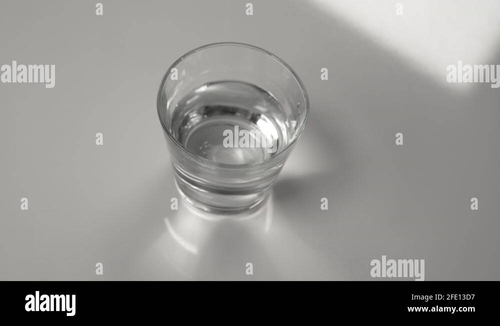 CLOSE UP: Water inside a transparent glass gets spilled during an ...