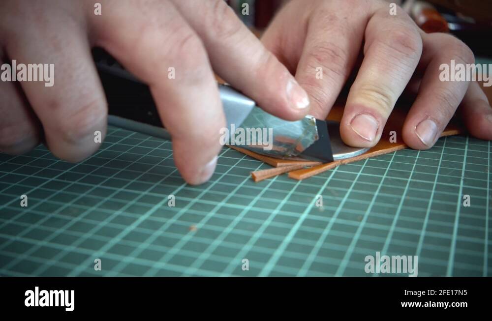 A stationery knife cuts the skin according to a stencil. Tanner's hands ...