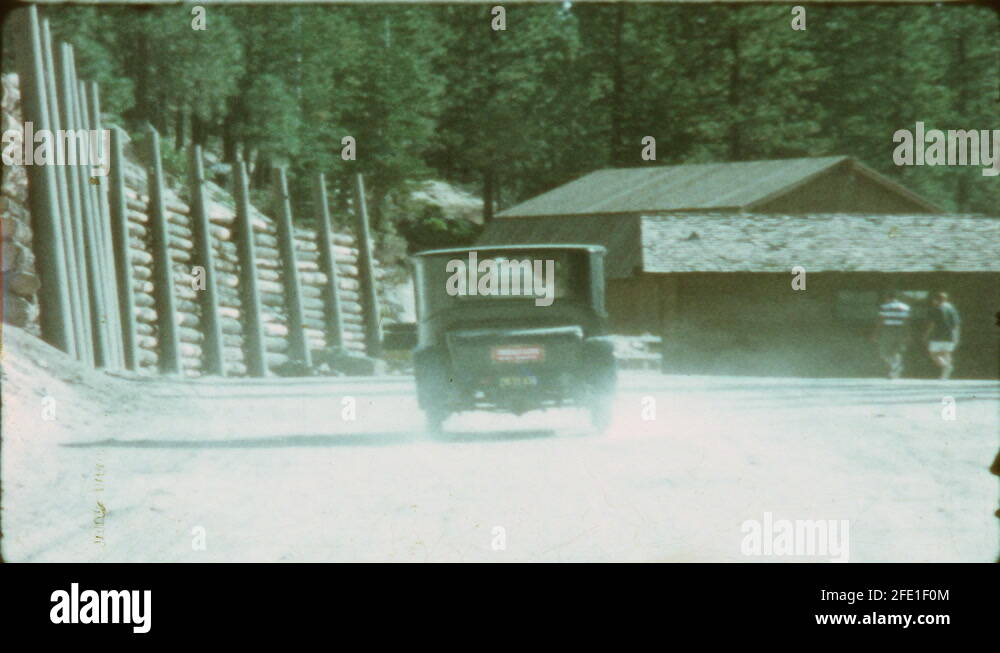 1960s: old-fashioned car driving in ranch, horse stable in front of ...