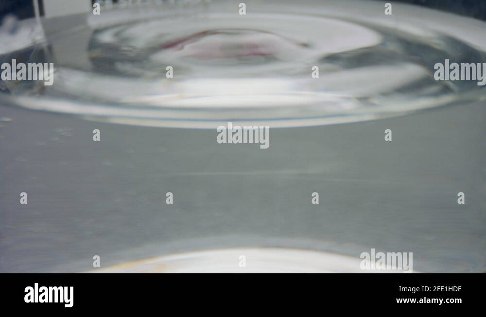 Closeup drops of blood falling in water. Laboratory glassware with ...