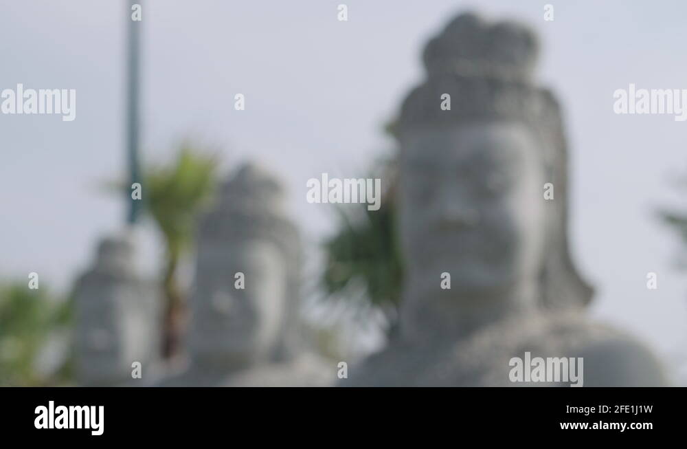 Rack focus on statues’s face by the Win Win memorial in Phnom Penh ...
