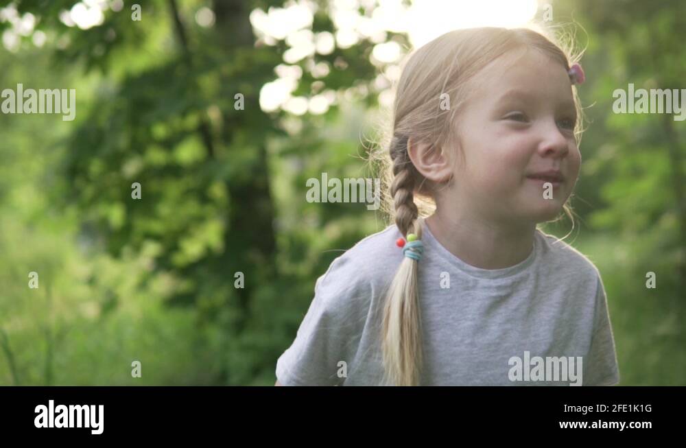 A beautiful little girl shows a Cool gesture and flirtatiously smiles ...