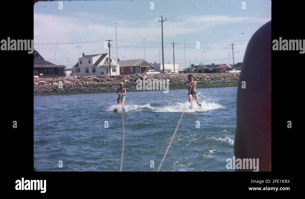1960s: Man and women waterski next to each other in slow motion Stock ...