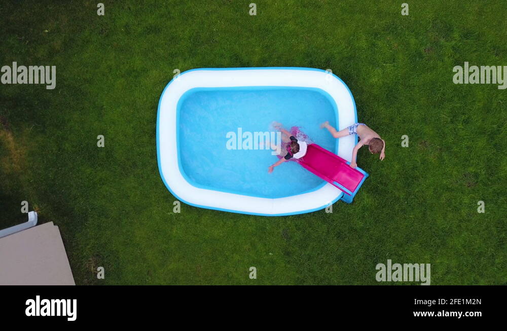 Little kids playing in a backyard wading pool Stock Video Footage - Alamy