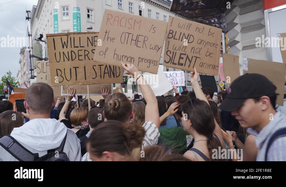A shot of a dense angry crowd consisting of young people holding signs ...