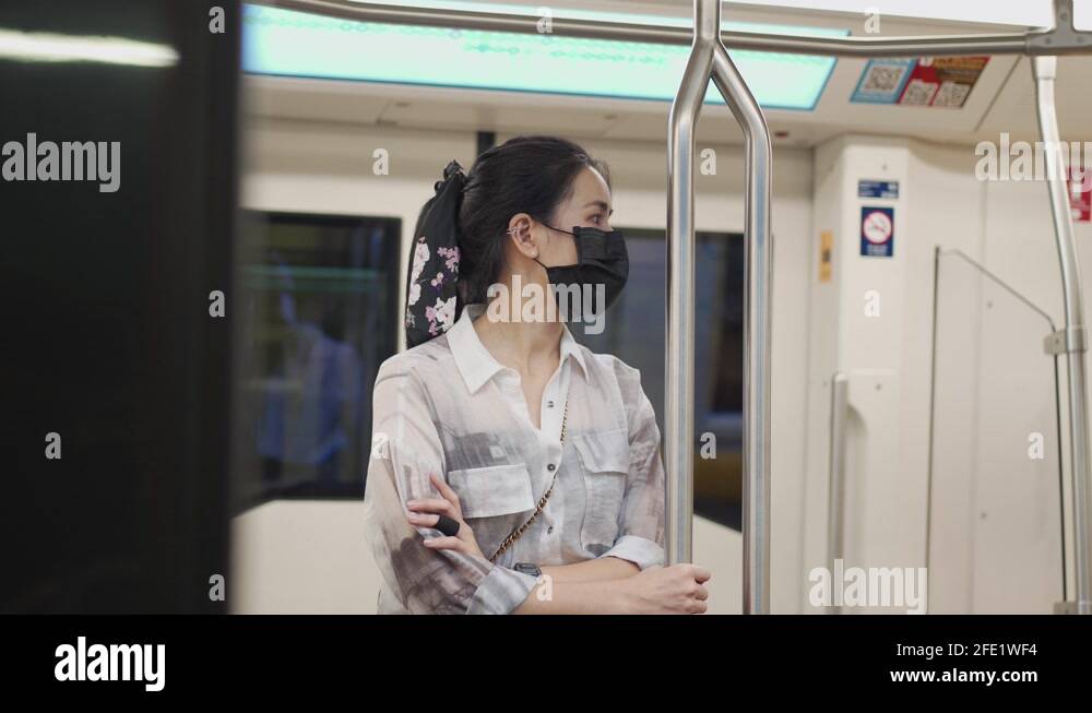 Asian female stand and holding subway pole for balancing inside subway ...