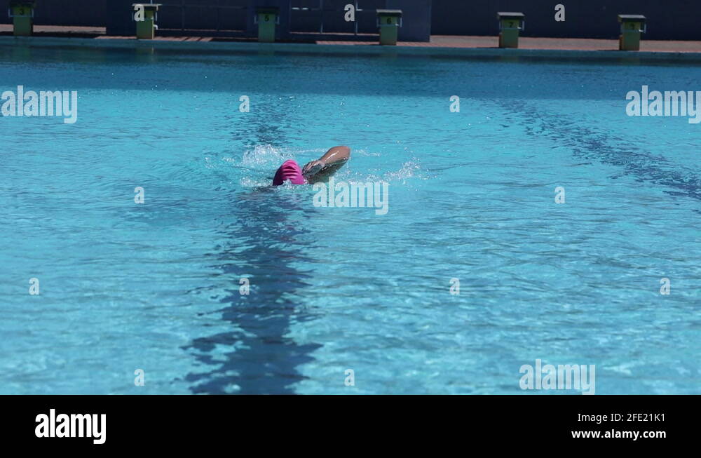footage of a female swimmer swimming laps in an outdoor pool using the ...