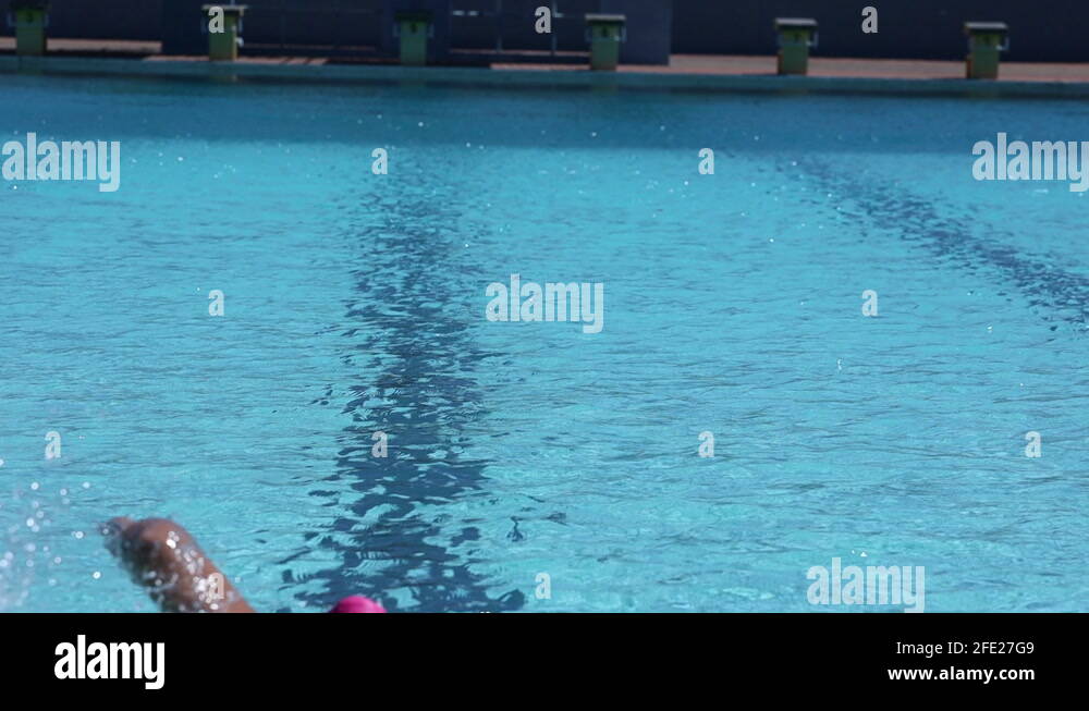 footage of a female swimmer swimming laps in an outdoor pool using the ...