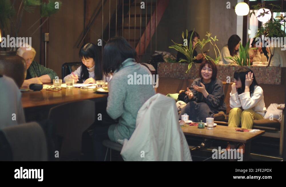 Japanese Customers Chatting And Working Inside A Cafe In Kyoto, Japan ...