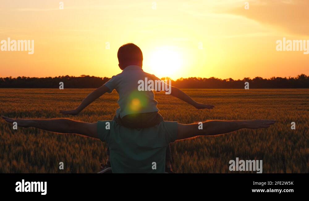 Father holding son on shoulders, imitating the flight of the aircraft ...