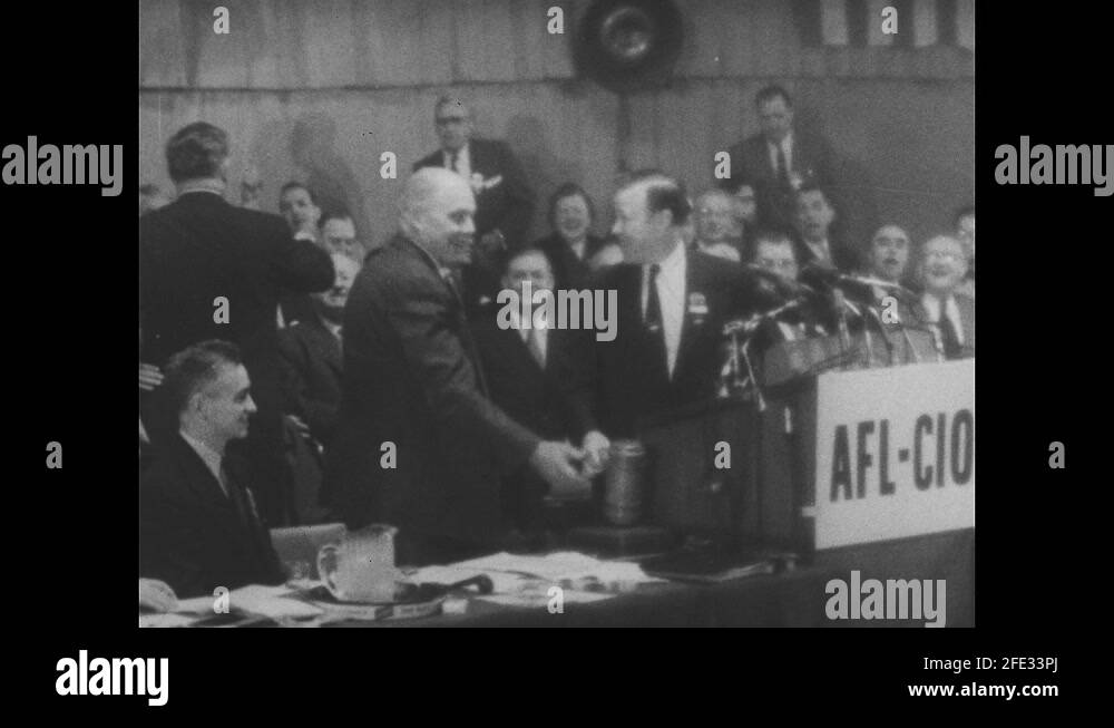 1960s: men on stage with AFL-CIO sign at podium, audience stands ...