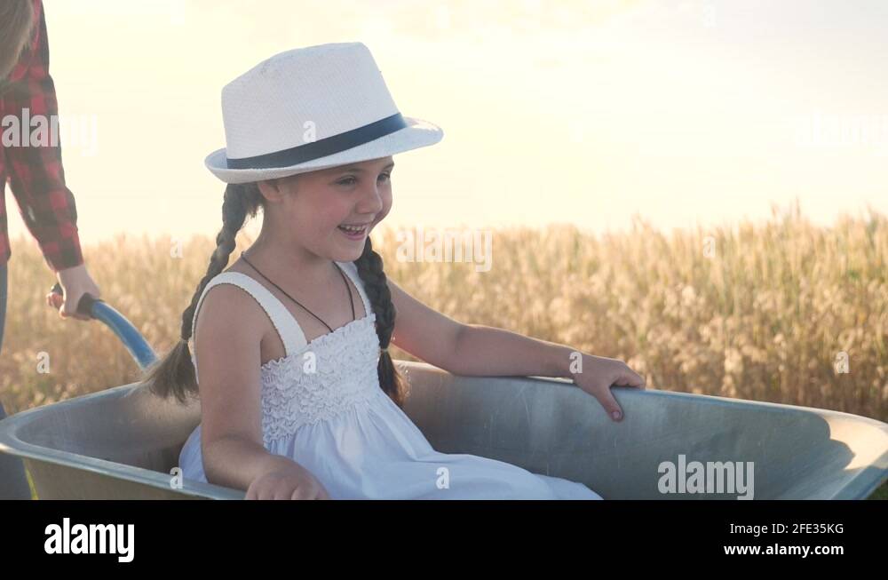 kid children play with a garden trolley car ride on wheelbarrow. little ...