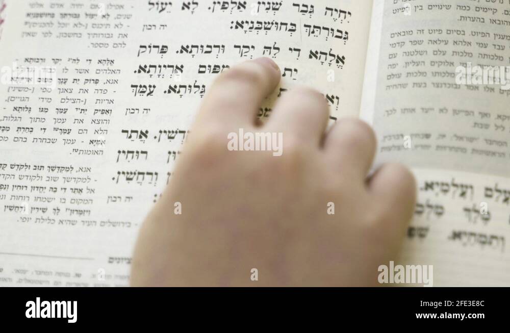 A boy reading a Hebrew holy book, Follows the reading with his finger ...