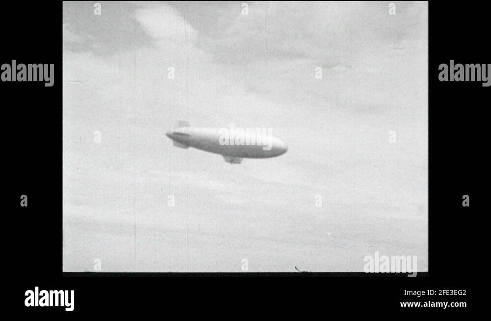 1940s: dirigible flying in air seen from rolling ship's deck, ship ...