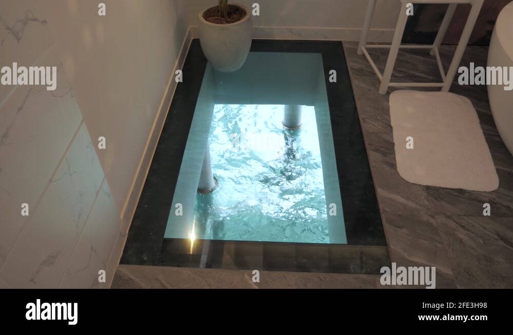 Glass floor to see swelling blue ocean water with plant in luxury ...