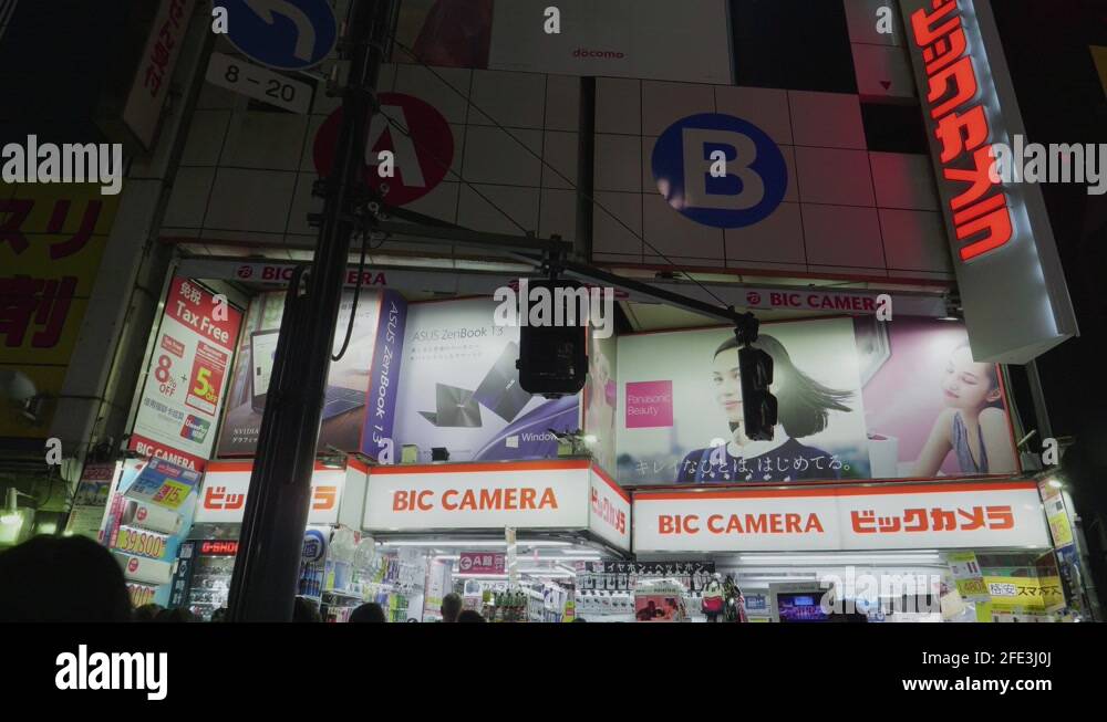 Handheld tracking shot of traffic light with background billboards in ...