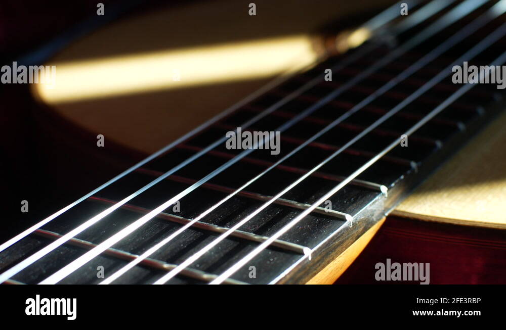 Guitar fretboard with frets and strings close up sliding shot with ...