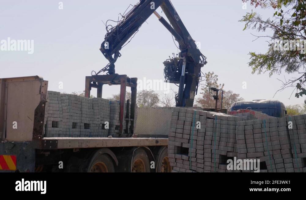 African Man unloading bricks from truck using a crane Stock Video ...